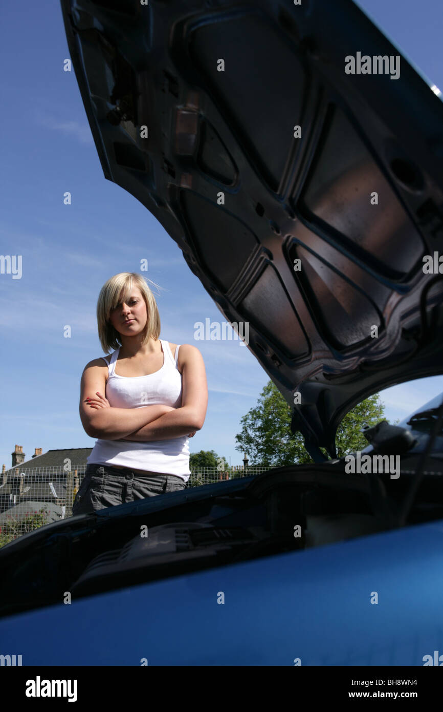 Blonde haired girl framed by the open bonnet of her car Stock Photo - Alamy