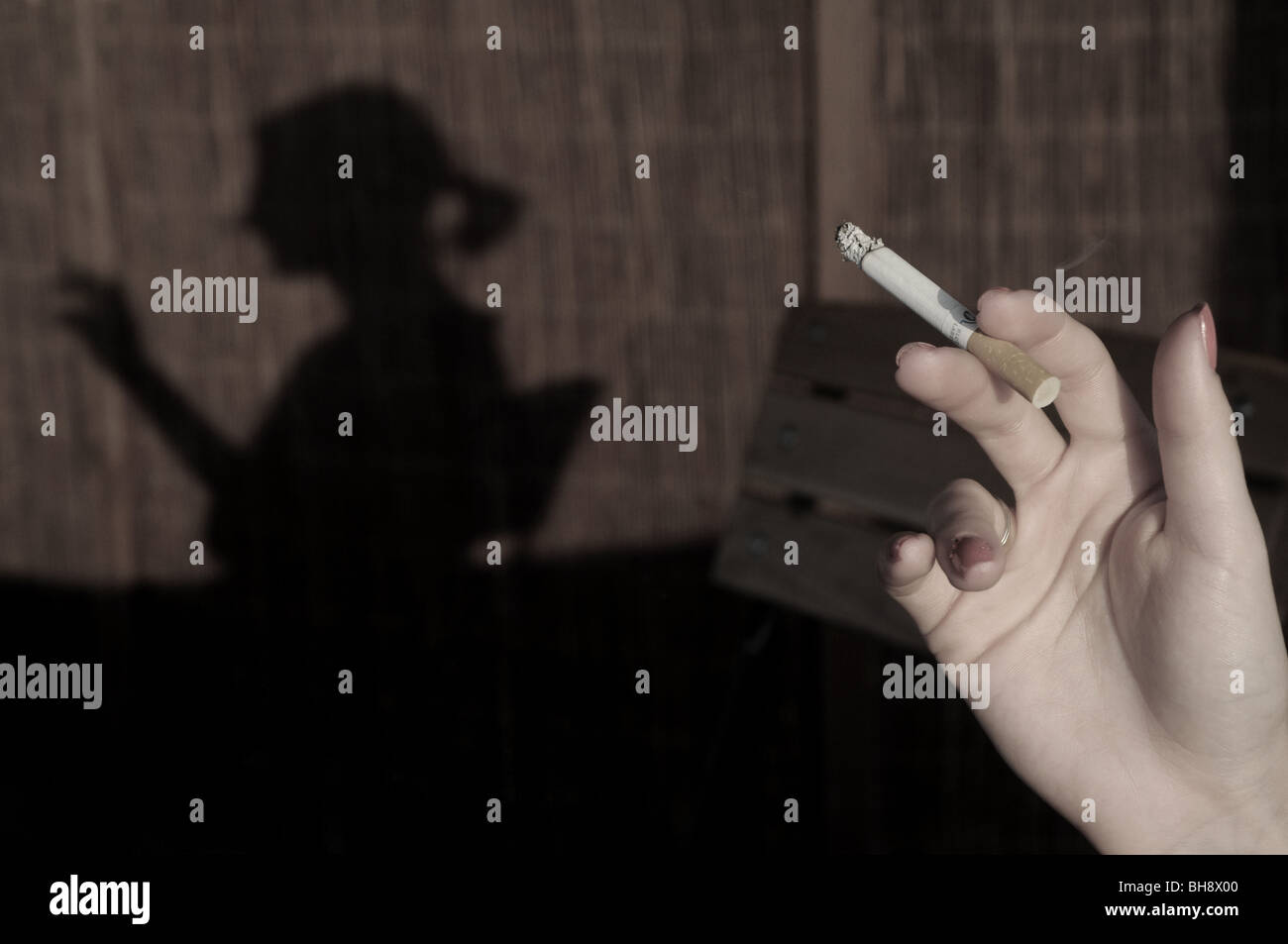 Shadow of young woman smoking cigarette Stock Photo - Alamy