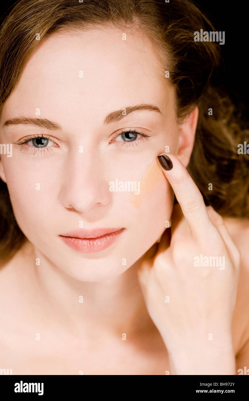Woman applying makeup foundation Stock Photo - Alamy