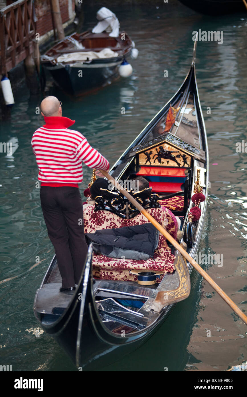 Gondolier leading tourists for a Venice gondola sight-seen. Italy Stock ...