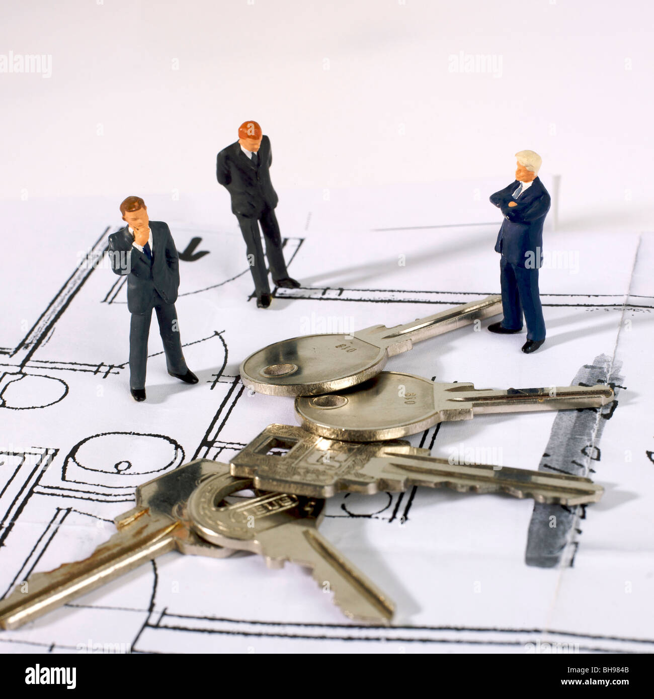 Architects, men, figurines, and keys of apartments on a construction ...