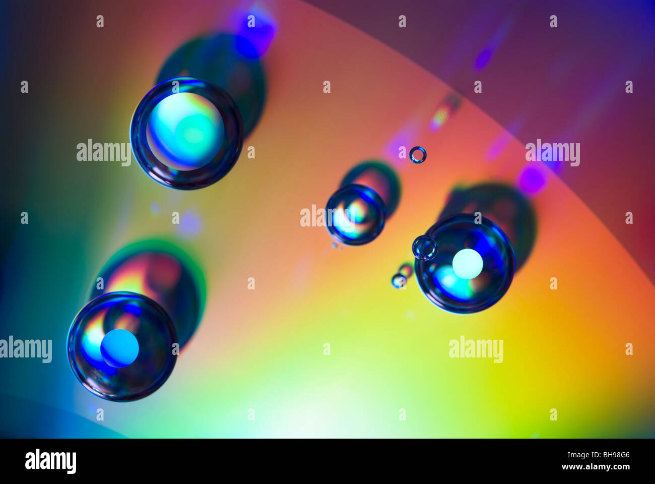 Drops of water in oil on a CD surface Stock Photo - Alamy