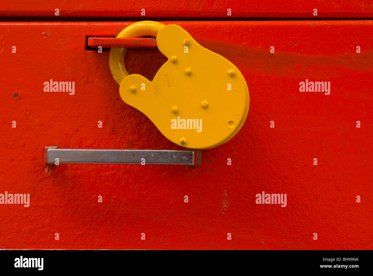 Yellow padlock on a red box Stock Photo - Alamy