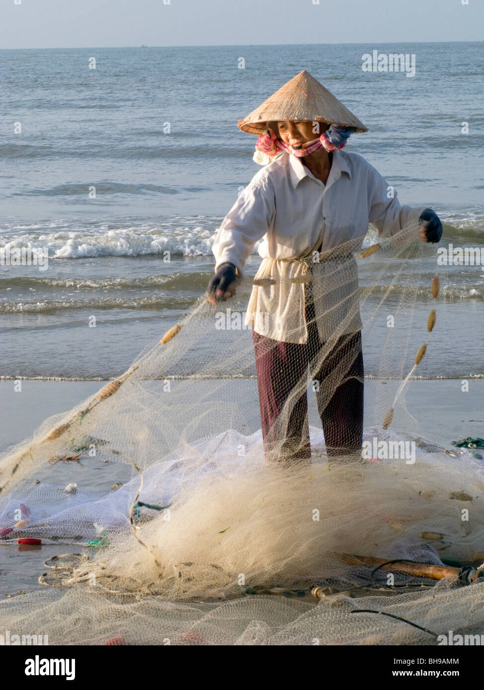 VIETNAM WOMEN FROM FISHING CO-OPERATIVE CASTING NET IN THE SEA NEAR MUI ...