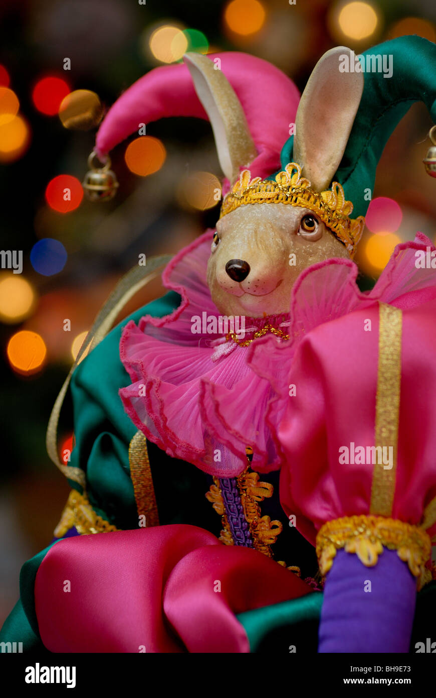 A Rabbit Court Jester holiday decoration in front of a lighted ...