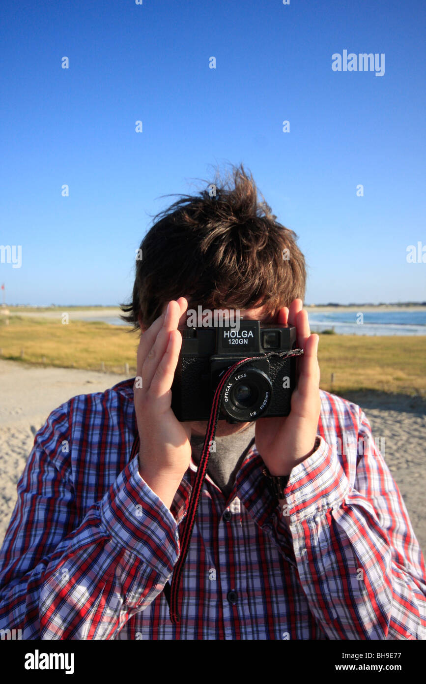 Man holding a camera infront of his face Stock Photo - Alamy