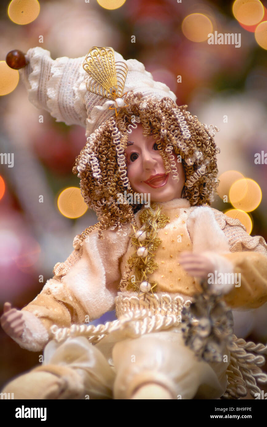 A Court Jester holiday decoration in front of a lighted Christmas tree ...