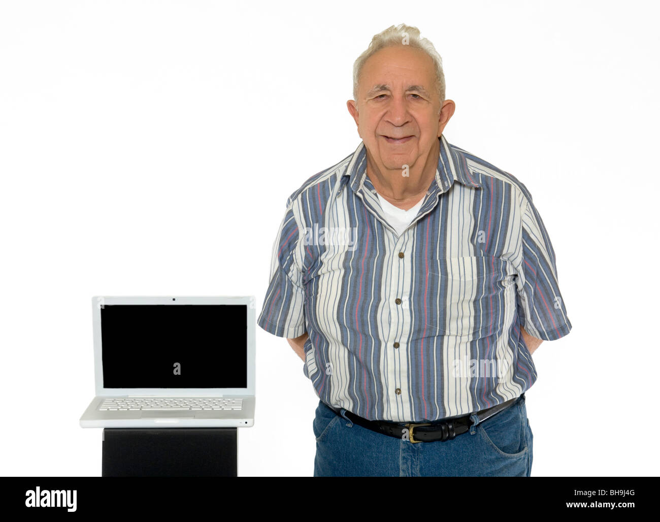 A senior retired elderly gentleman stands next to a laptop computer ...