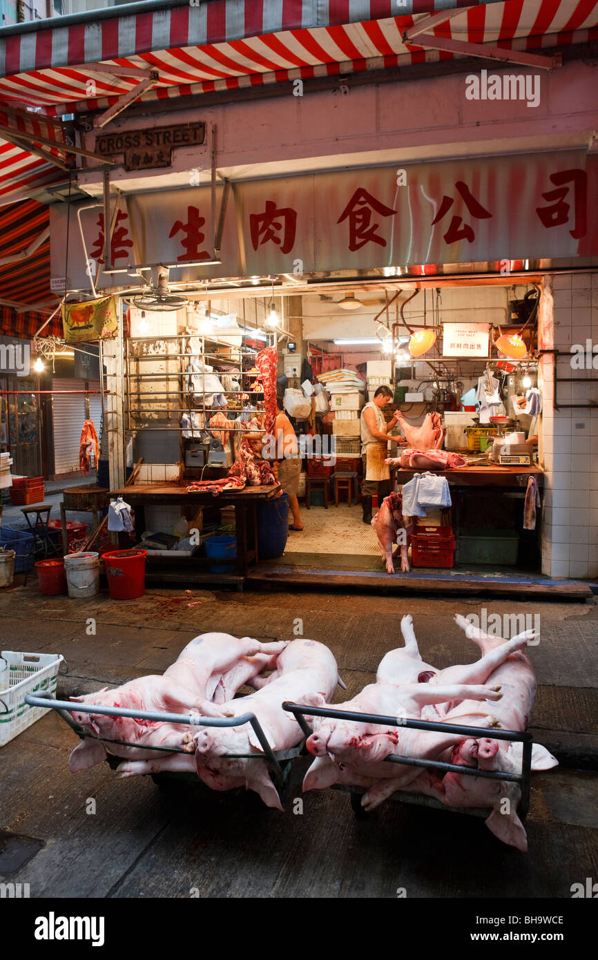 Slaughtered pigs outside a butcher shop on the Wanchai Road street ...