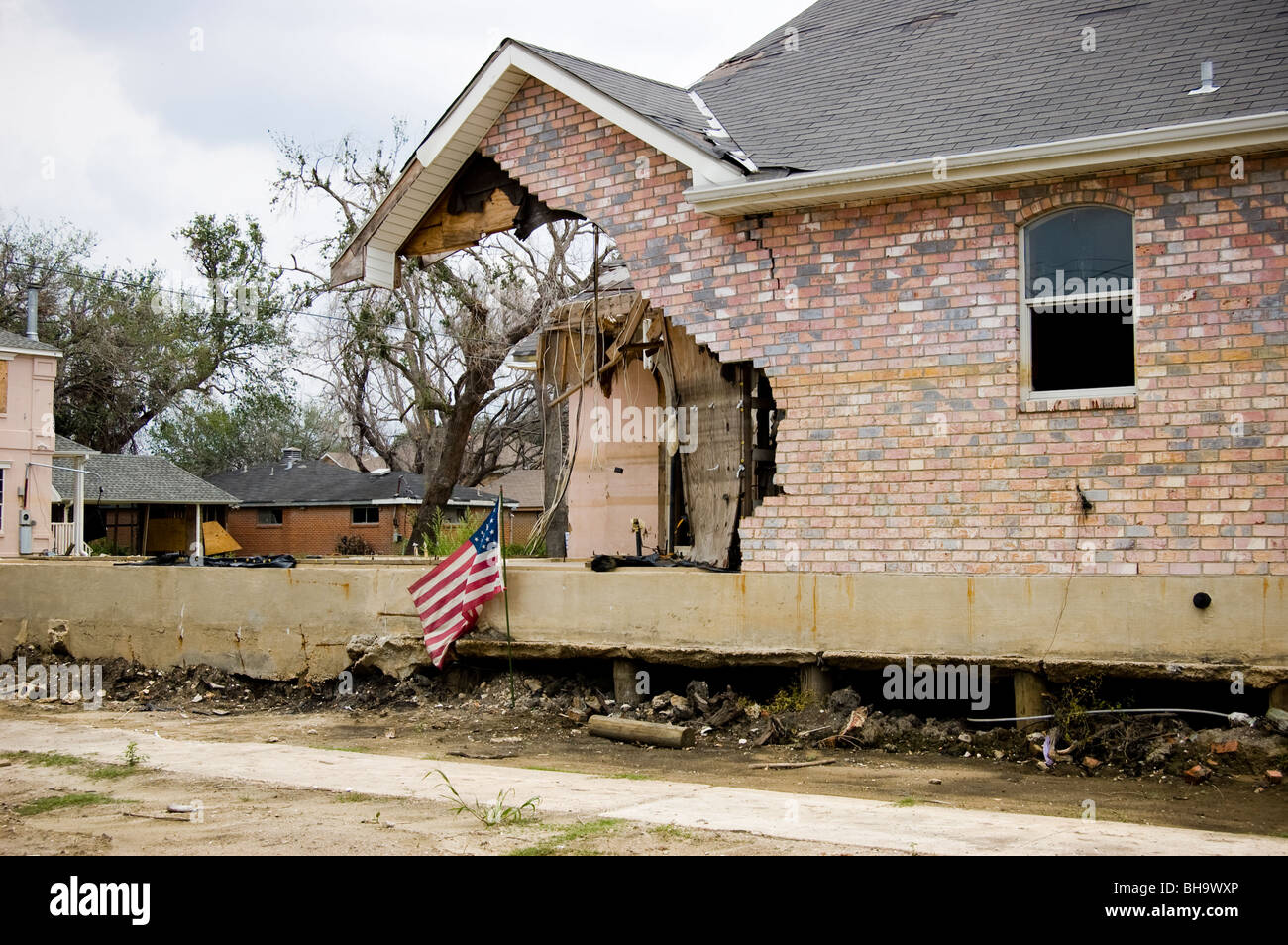 A partially destroyed home with an American flag in front. 9 months ...