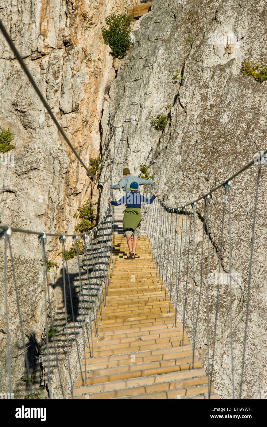 Man and his son crossing the swinging foot bridge on the Via Ferrata at ...