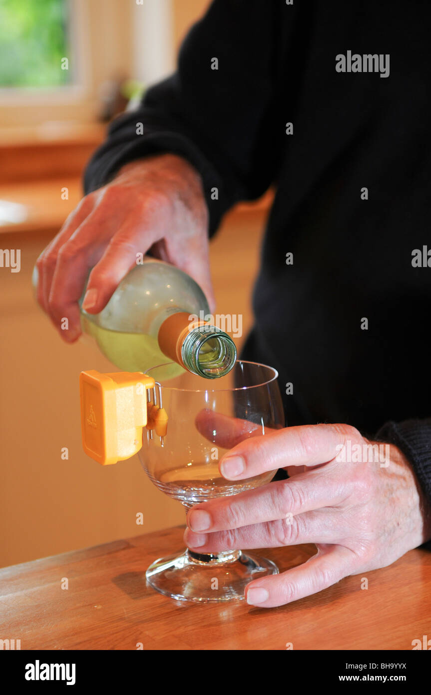 Blind man pouring chilled white wine into a glass using a bleeping ...