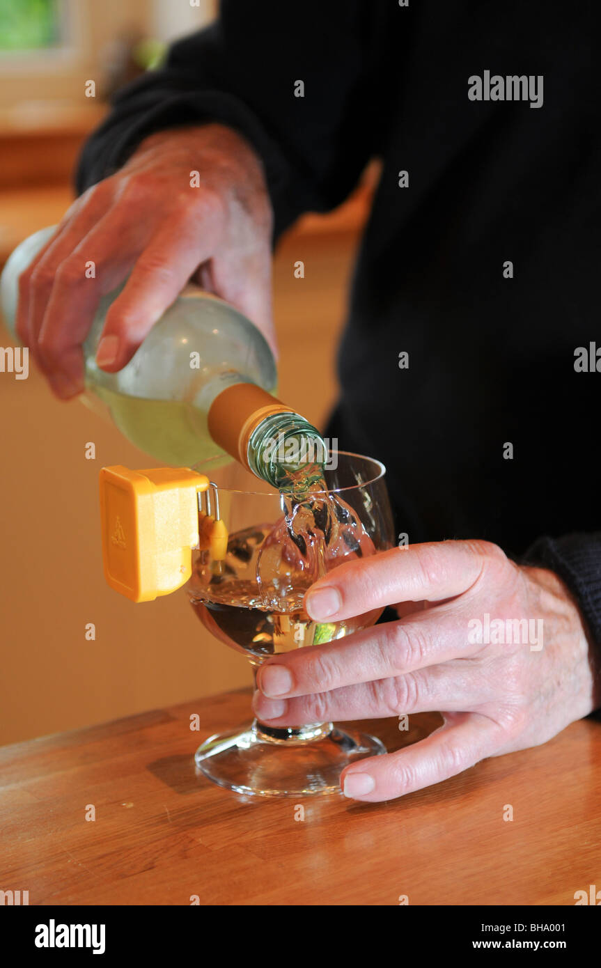 Blind man pouring chilled white wine into a glass using a bleeping ...