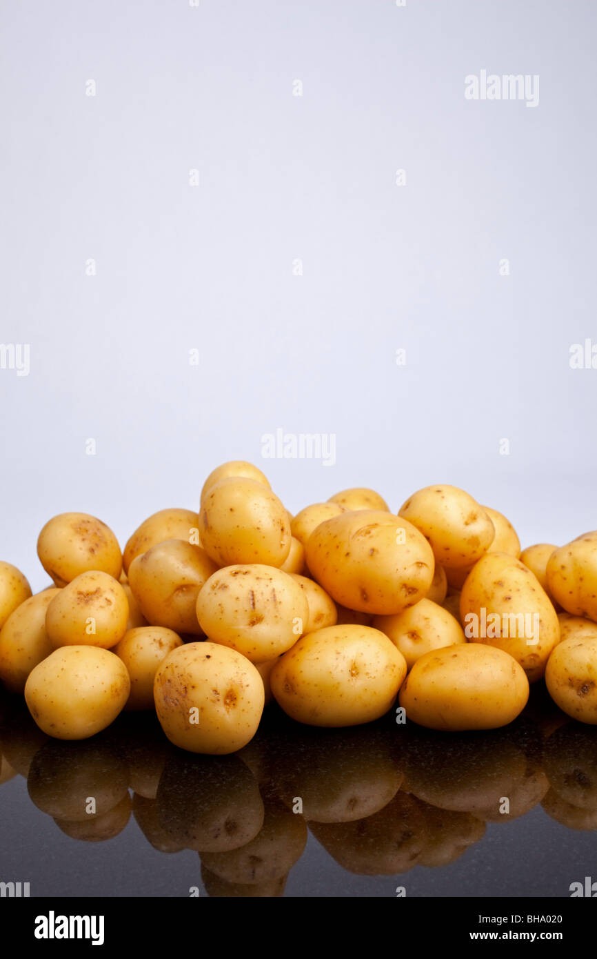 a random pile of small new potatoes on a black surface Stock Photo - Alamy