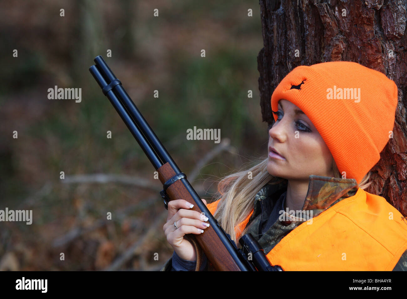 CLOSE UP YOUNG WOMAN 21 Y.O. FEMALE DEER HUNTER SITTING AGAINST TREE IN ...