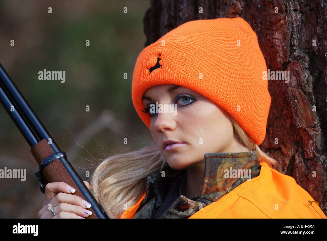 CLOSE UP YOUNG WOMAN 21 Y.O. FEMALE DEER HUNTER SITTING AGAINST TREE IN ...