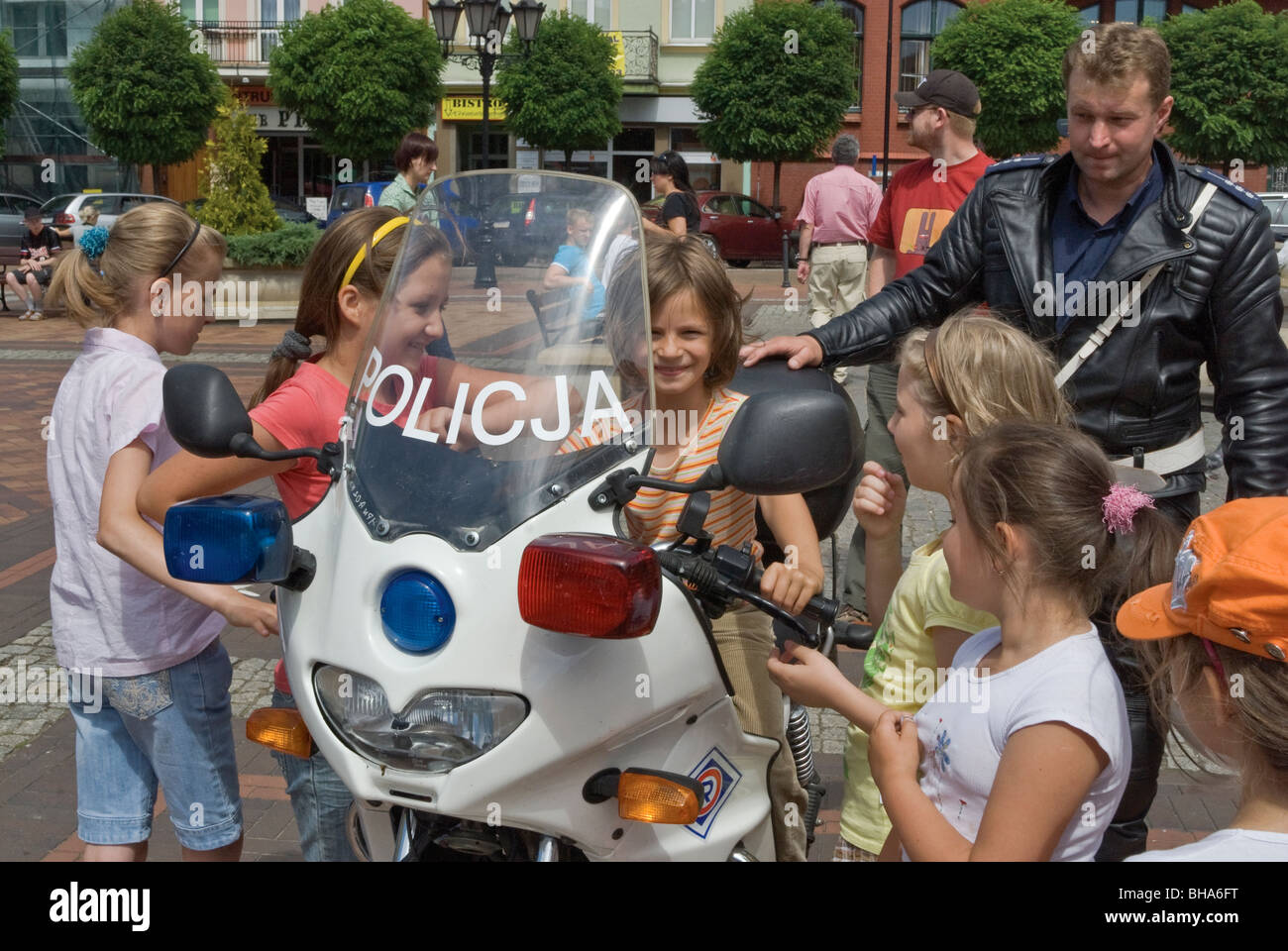 Police officer showing his motorcycle to young girls during Police ...