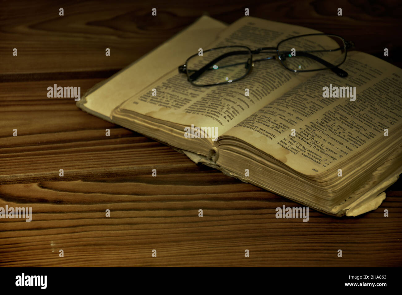 Glasses and old book (dictionary) on a wooden desk Stock Photo - Alamy