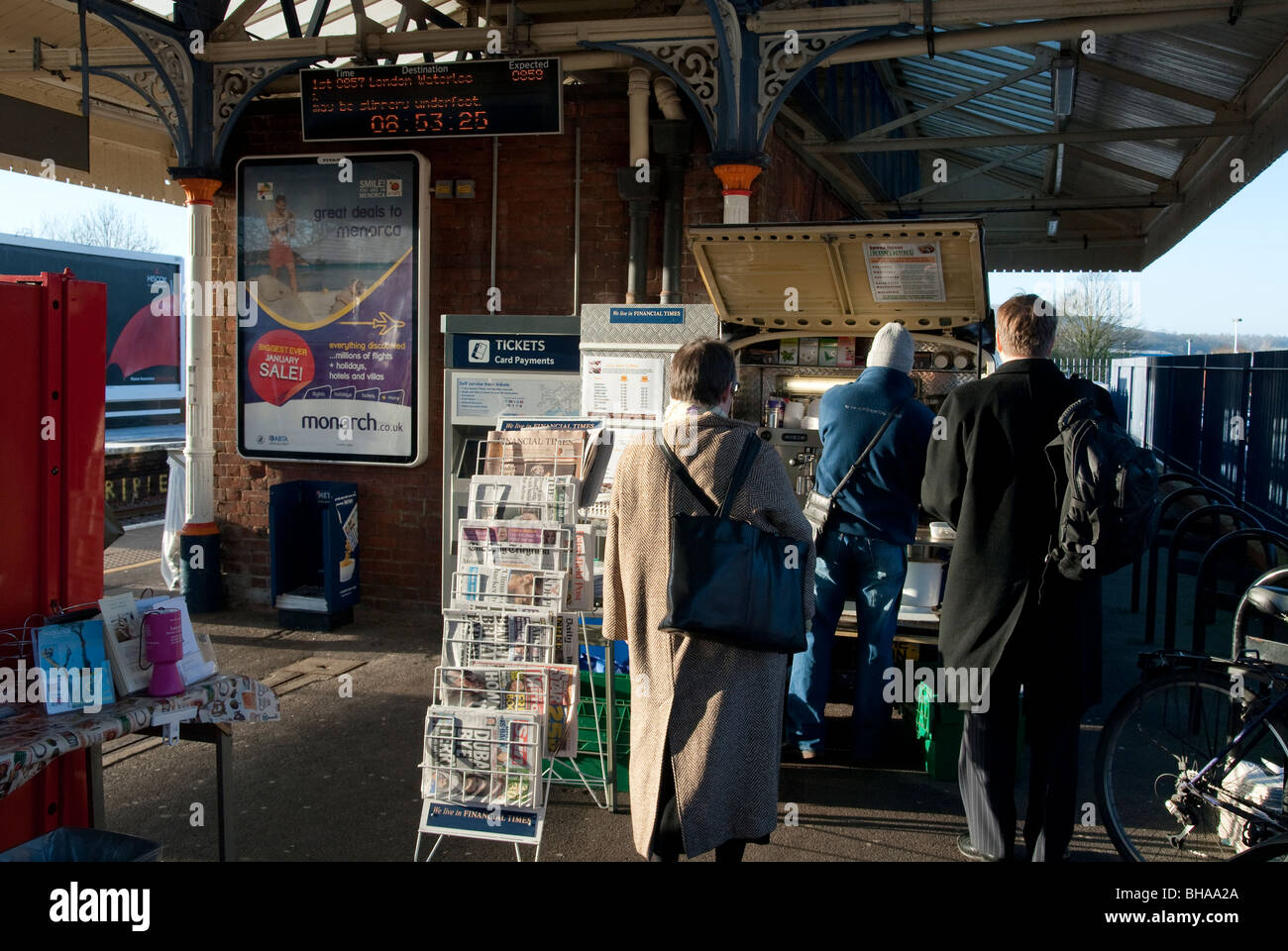 Passengers using on platform snack and coffee bar for morning commuters ...