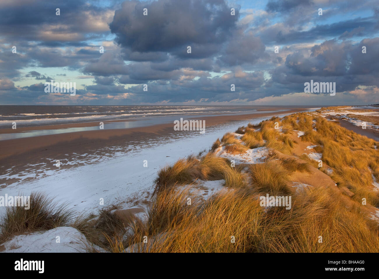 Snow covering the sand dunes and beach at Holkham bay on the Norfolk ...