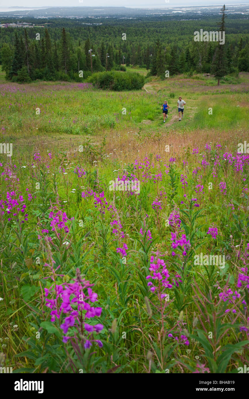 A young couple run up a trail at the Hilltop Ski area east of Anchorage ...