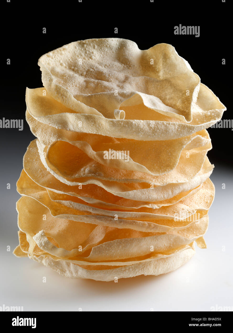 A pile of poppadoms on a white background Stock Photo - Alamy