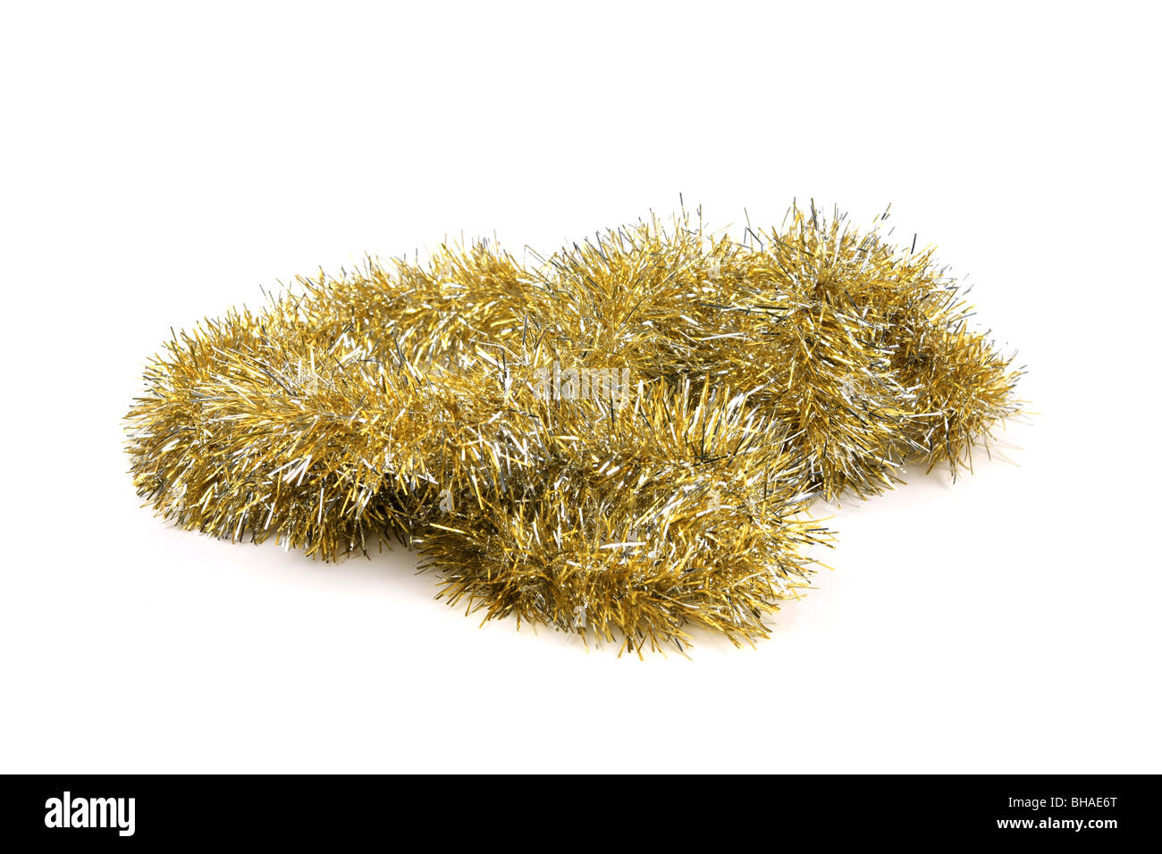Gold Tinsel against a white background Stock Photo - Alamy