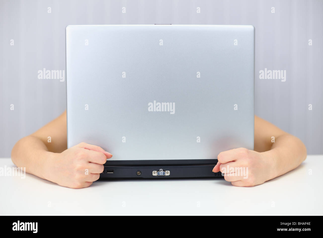 Emotional woman hiding behind a screen laptop Stock Photo - Alamy