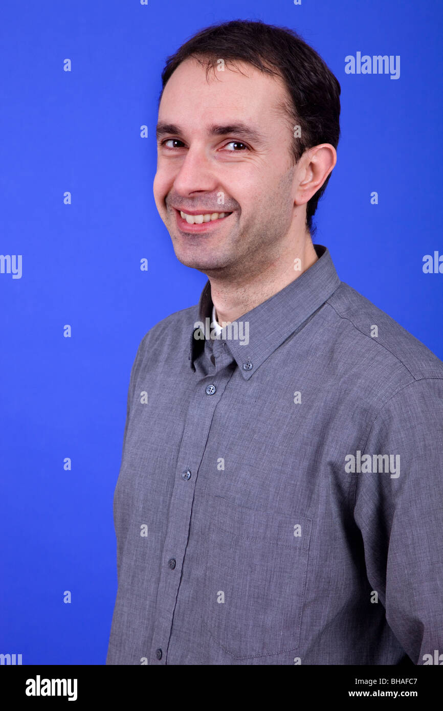 an young man portrait over a blue background Stock Photo - Alamy
