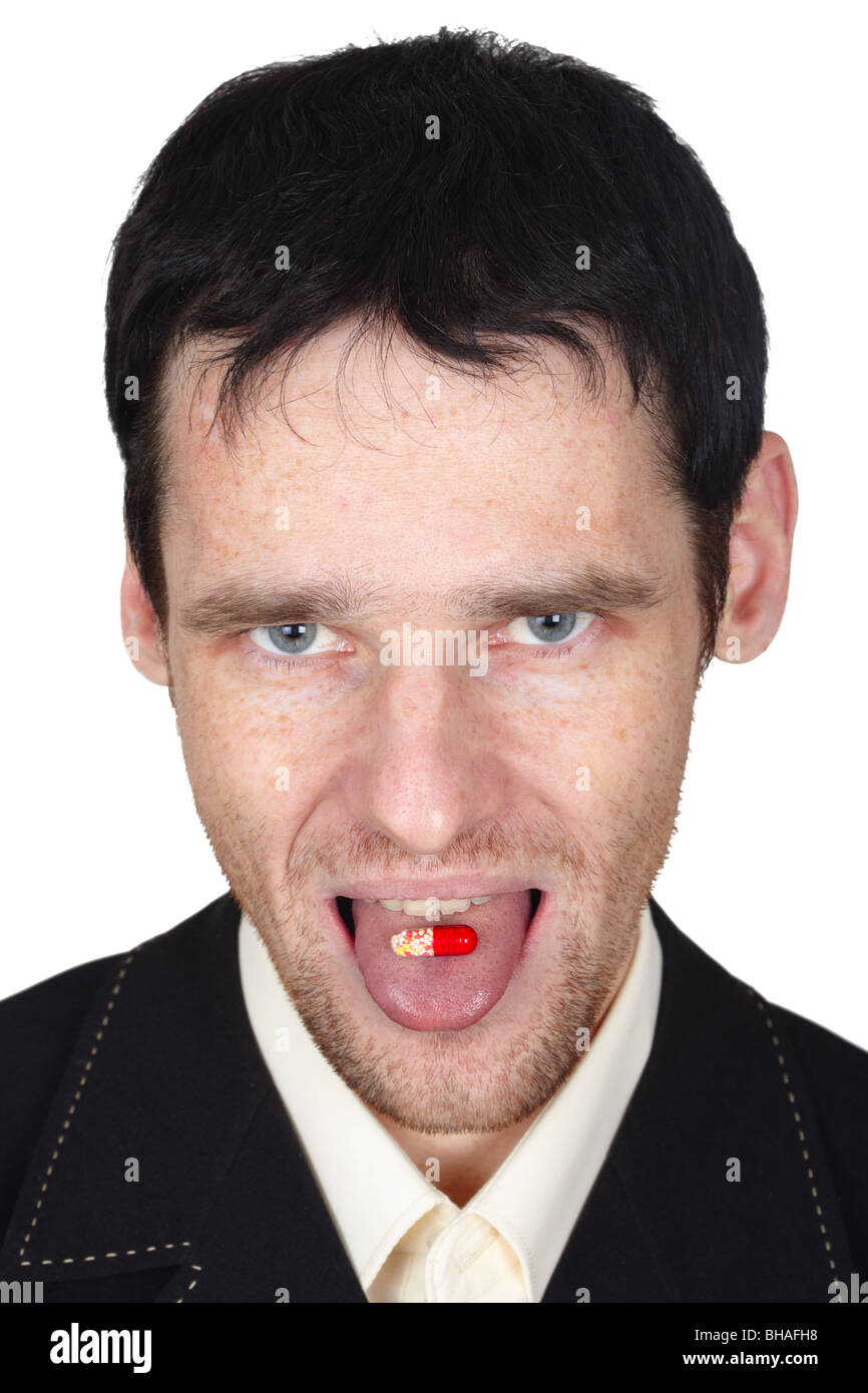 A young man eats a pill put it on the tongue Stock Photo - Alamy