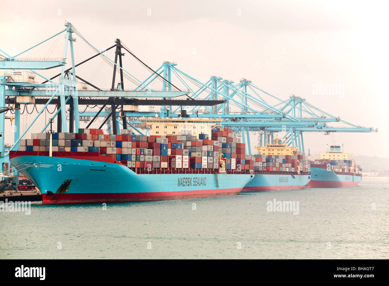 A fleet of Maersk container ships loading and unloading cargo in the ...