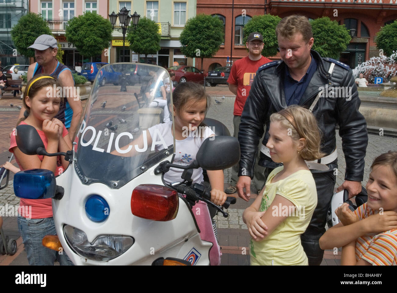 Police officer showing his motorcycle to young girls during Police ...