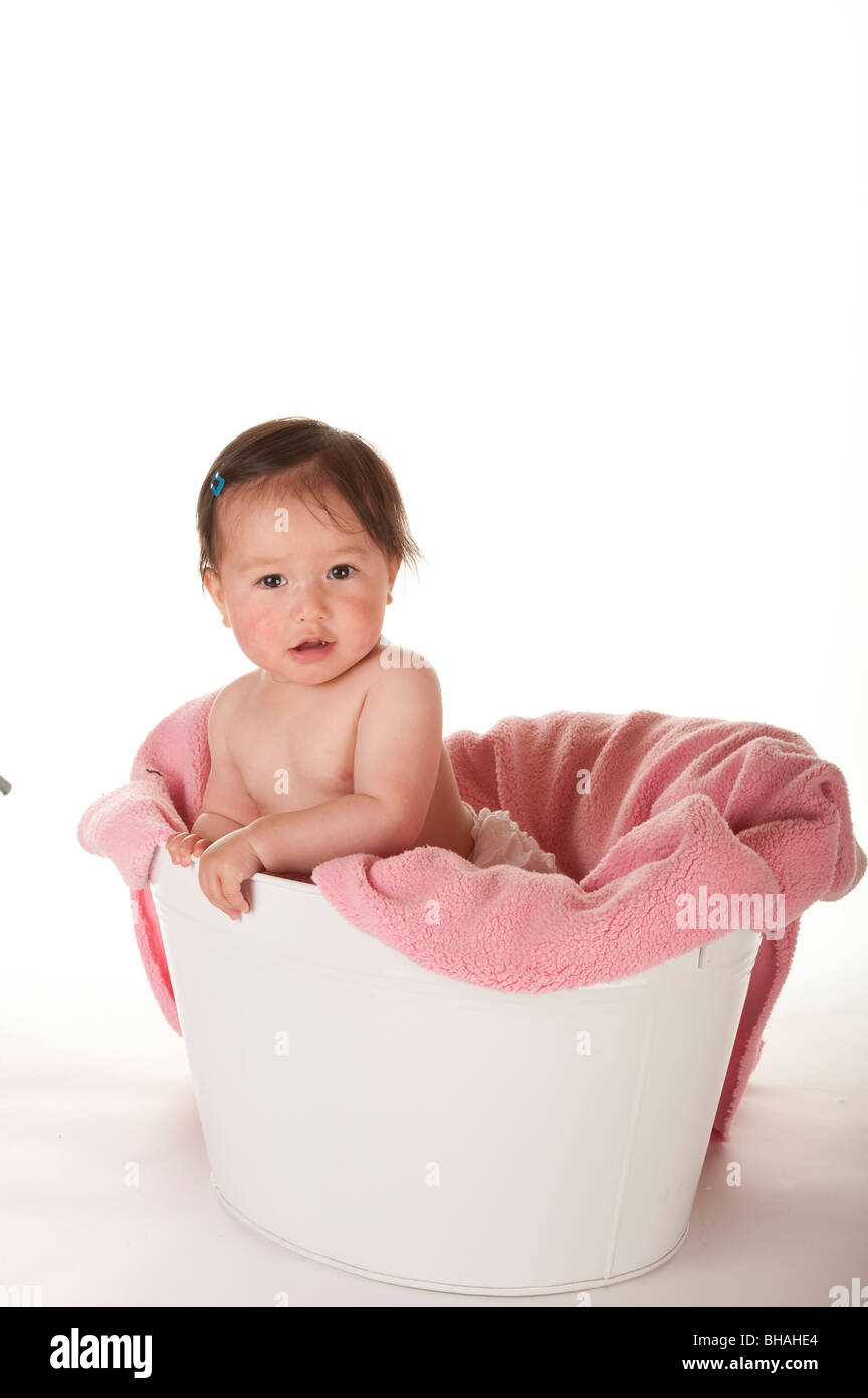 very cute Pacific Islander baby girl sitting in white tub with pink ...