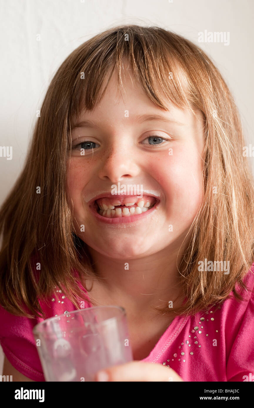 little girl who is smiling through missing two front teeth enjoying ...