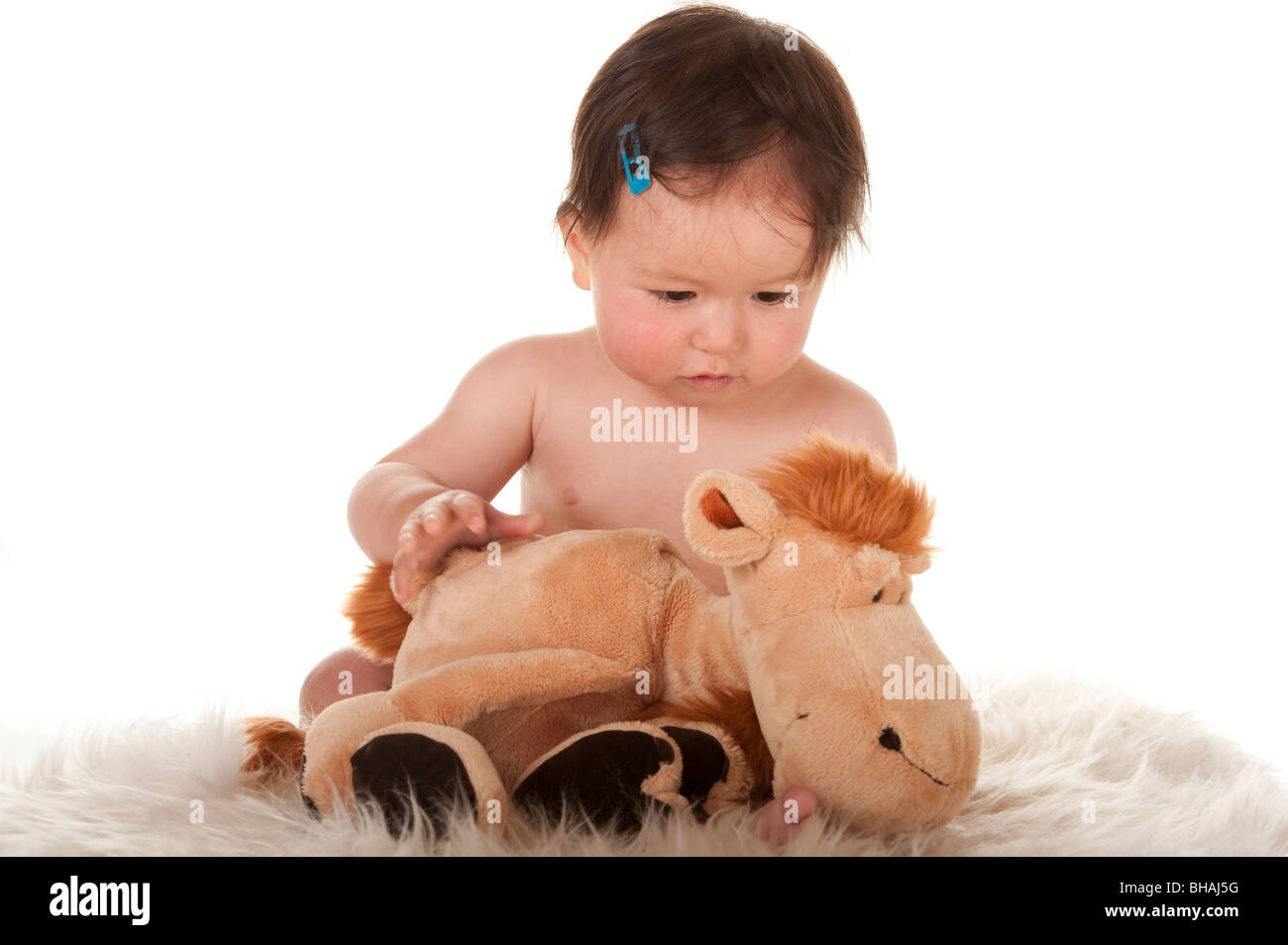 Pacific Islander baby girl exploring and playing with toy stuffed ...