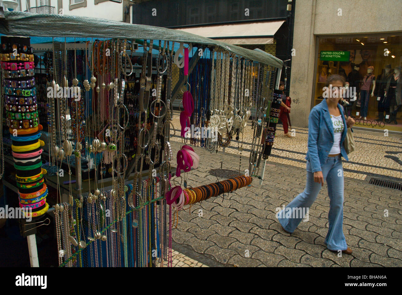 Woman passing a stall selling trinkets Porto Portugal Europe Stock ...