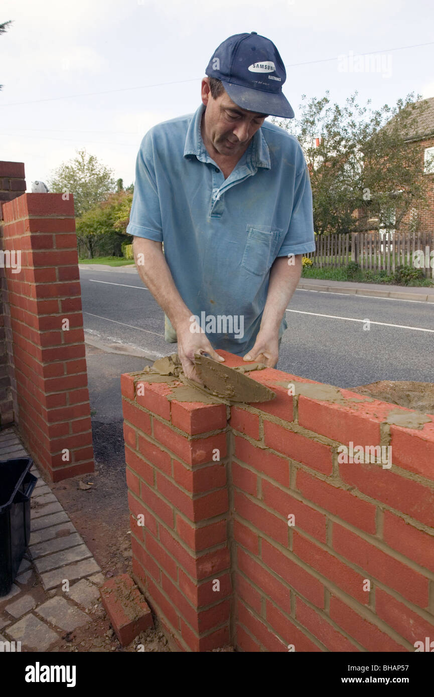 Bricklayer making a wall Stock Photo - Alamy