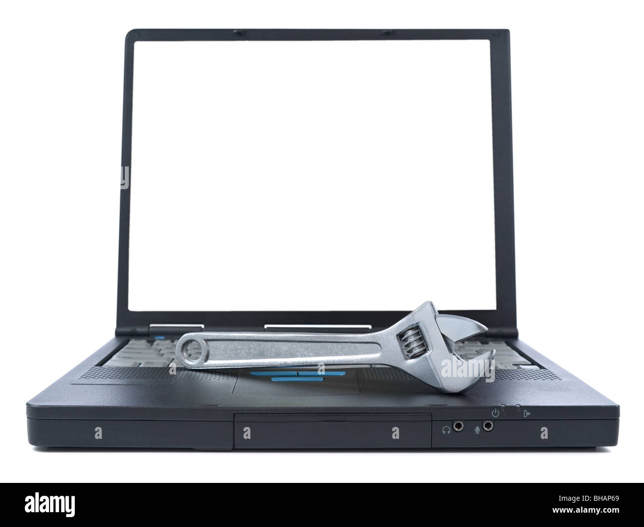 A spanner over a black laptop isolated over white background. White ...