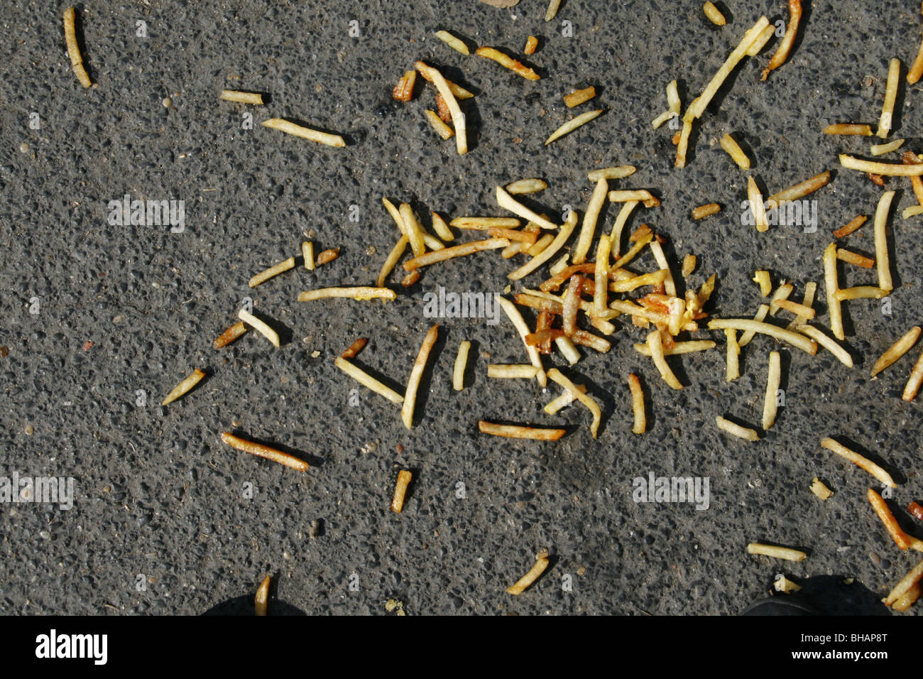 lots of french fries chips on street in sun Stock Photo - Alamy