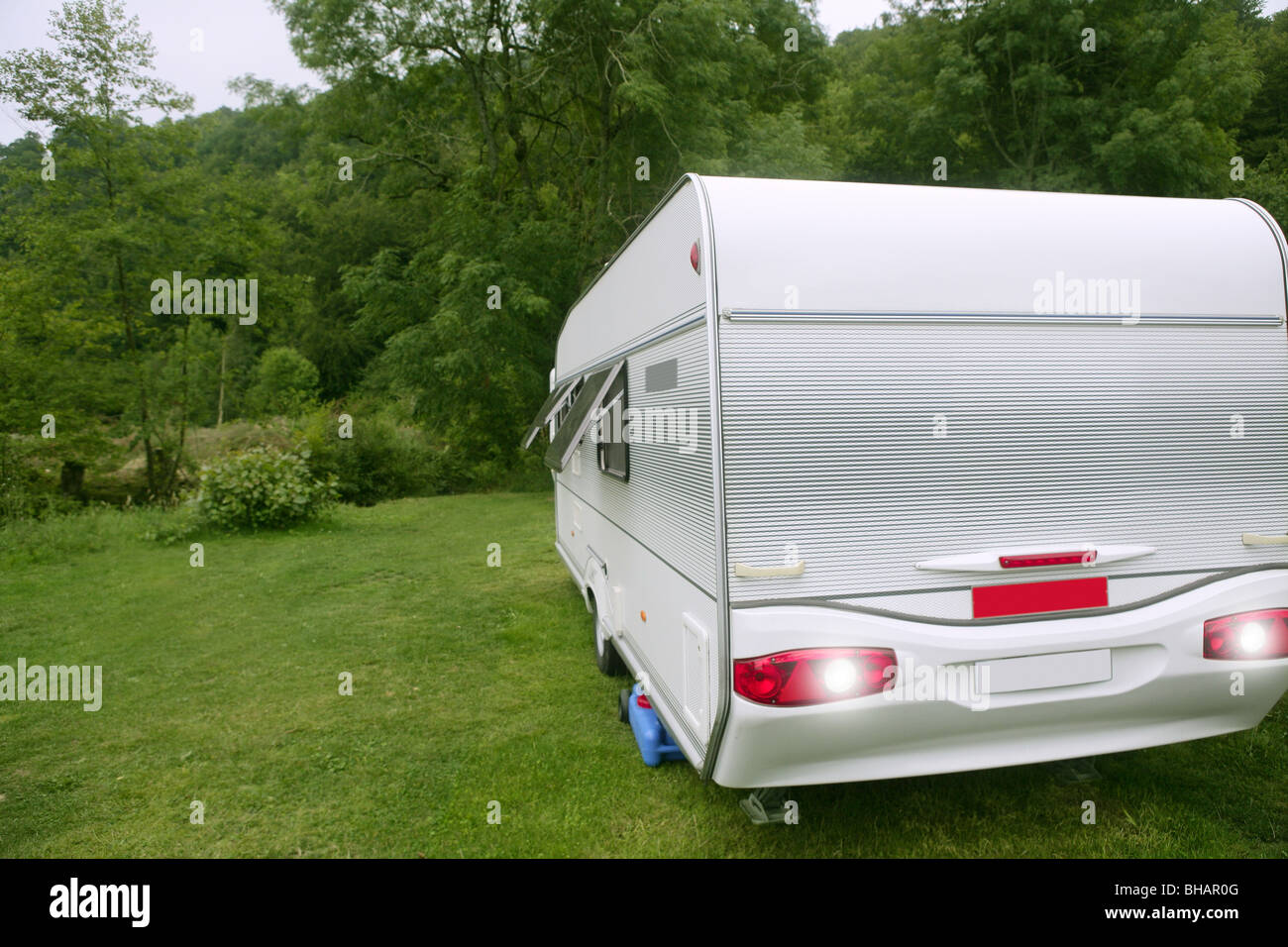 Caravan van in the green meadow forest camping Stock Photo - Alamy