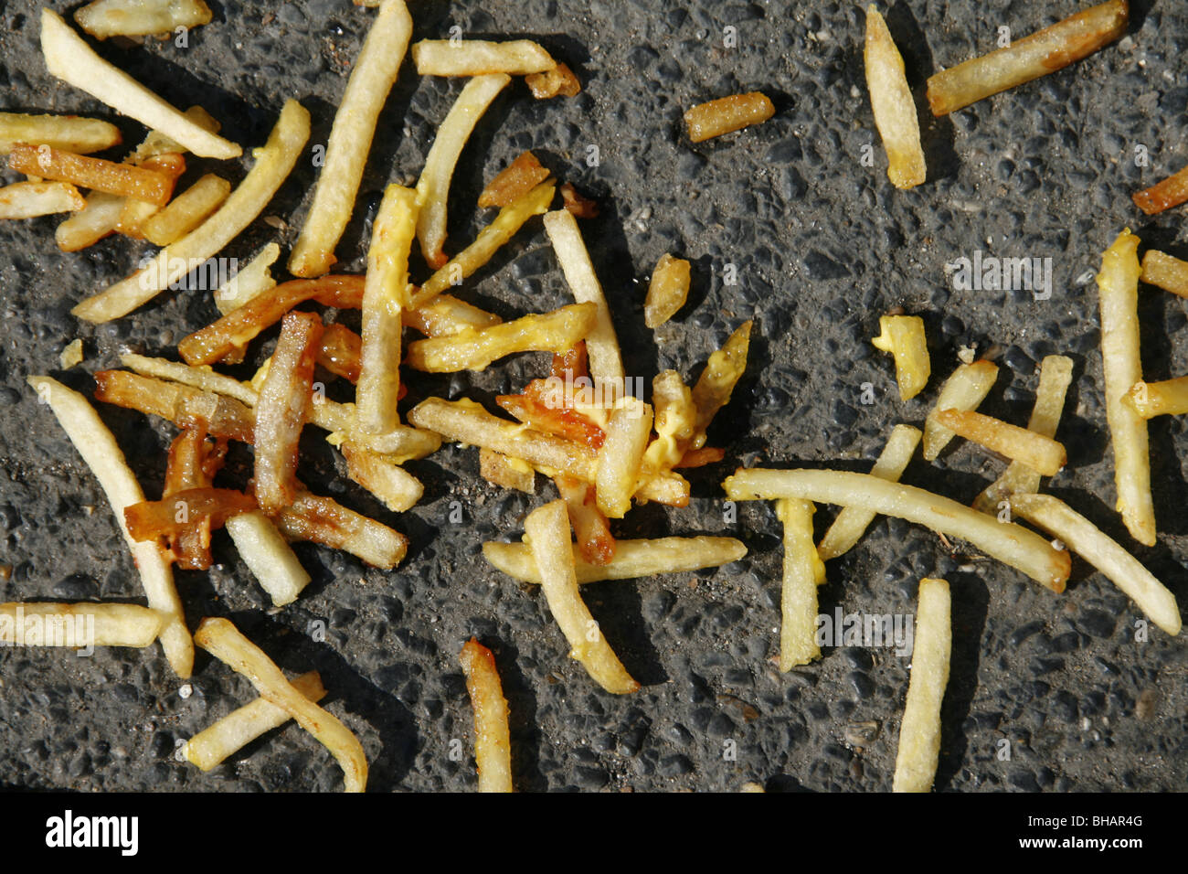 lots of french fries chips on street in sun Stock Photo - Alamy