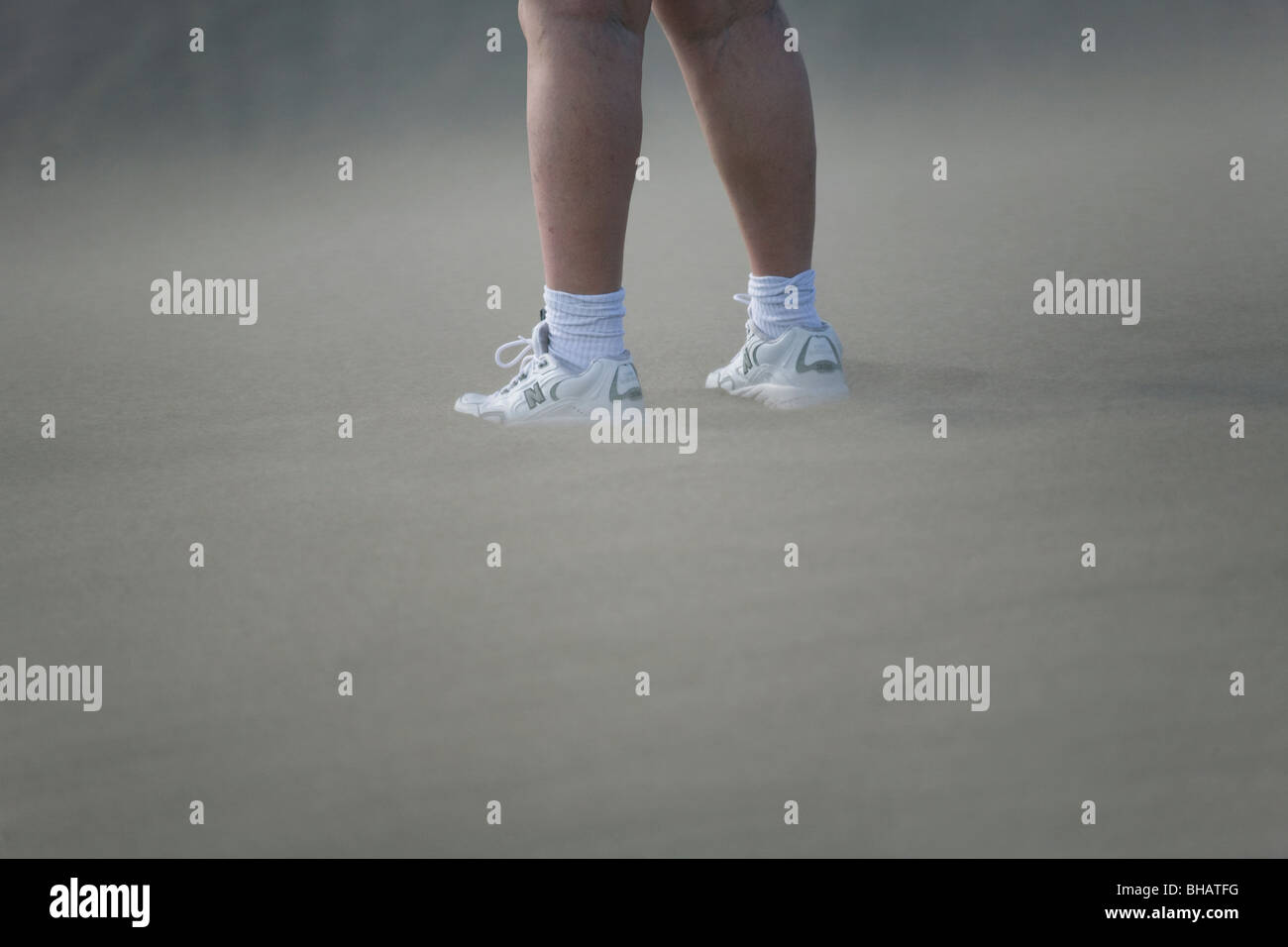 Wind blows sand around the feet of a visitor in Great Sand Dunes ...