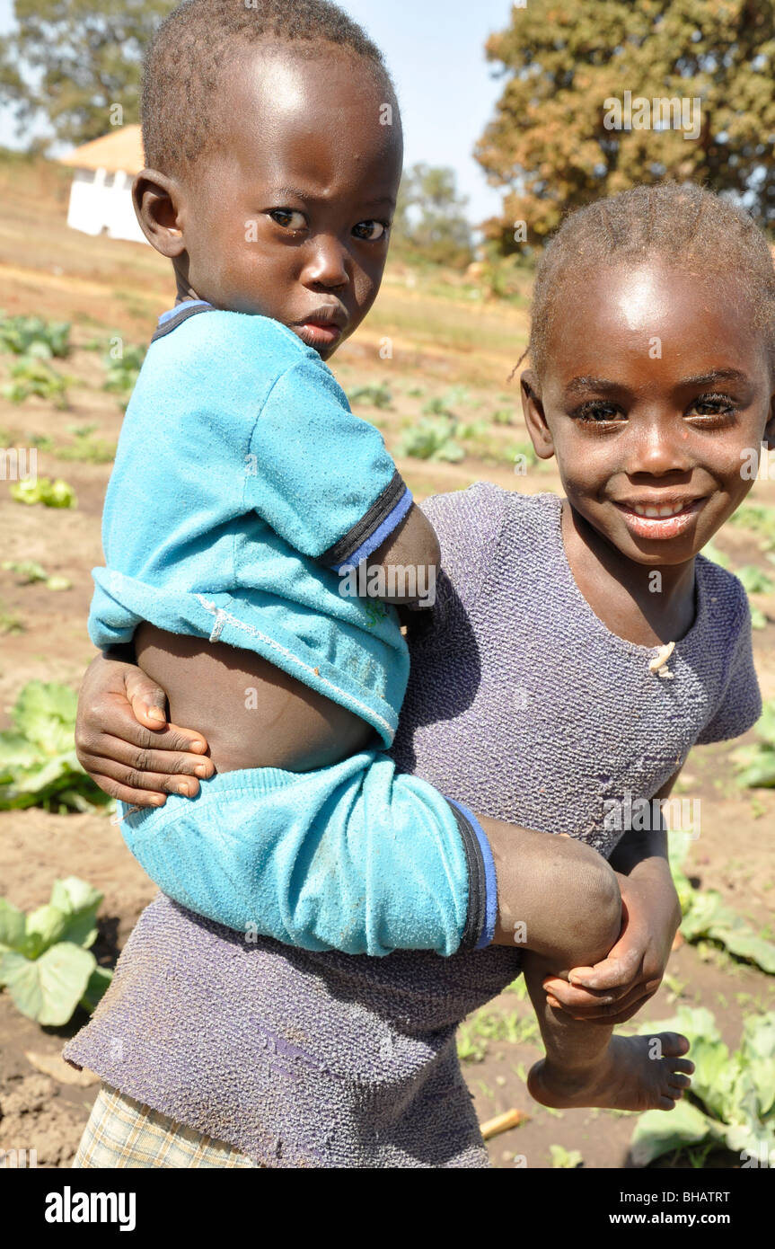 Heavy carrying for a six year old girl, The Gambia Stock Photo - Alamy
