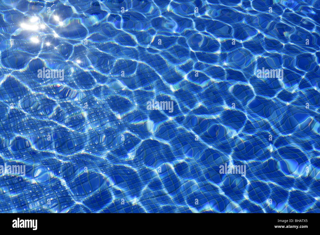 Blue water texture, tiles pool in sunny day with light reflections ...
