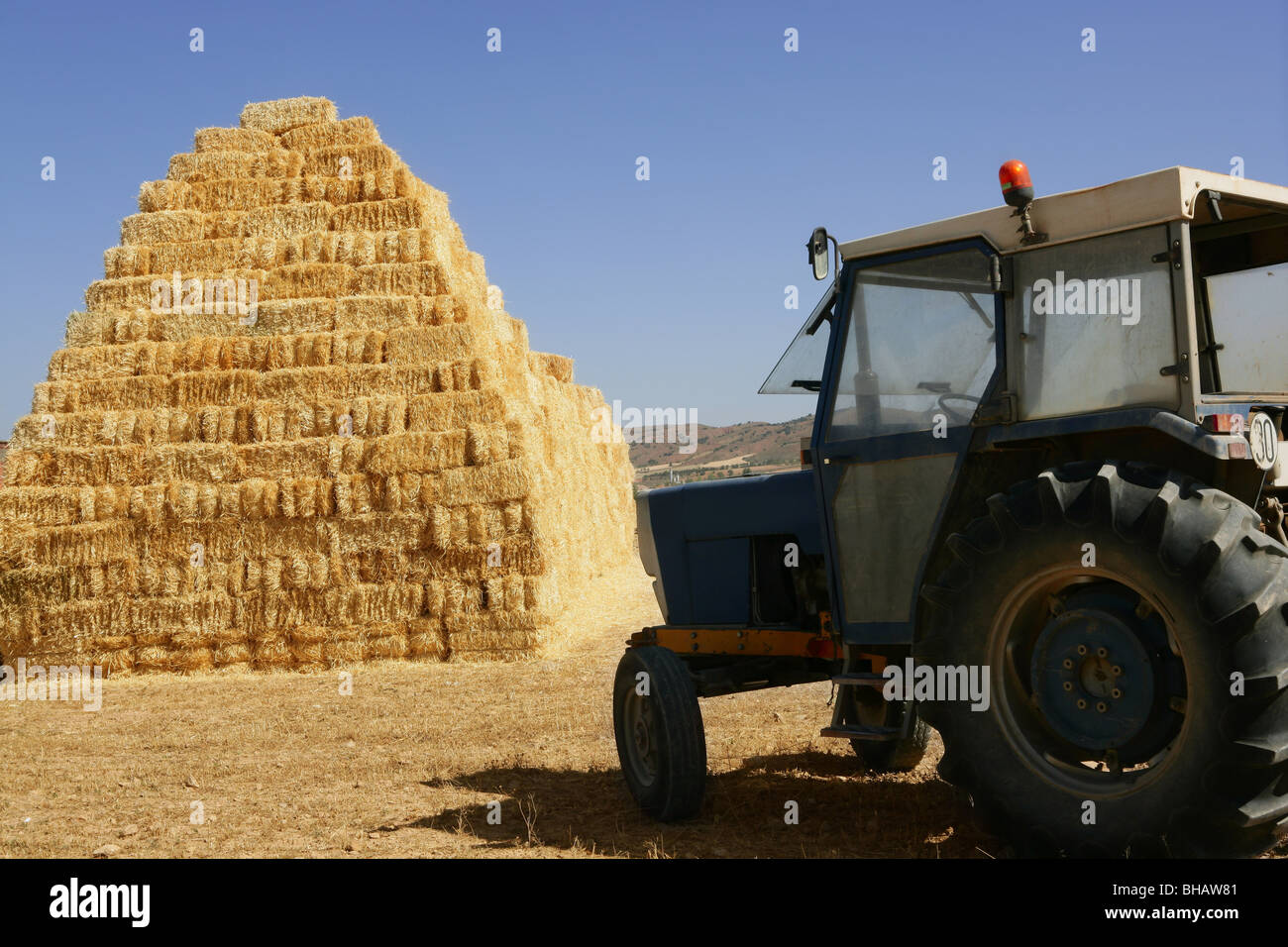 Barn stacked with piramyd shape and agriculture tractor vehicle Stock ...