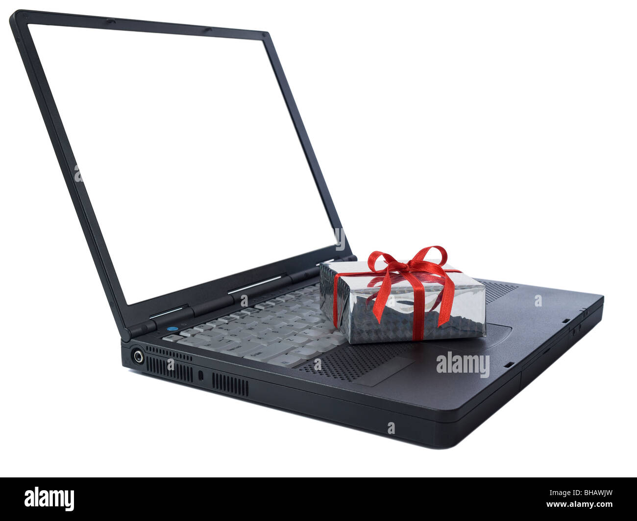 Small gift wrapped with a red ribbon over a black laptop isolated on ...