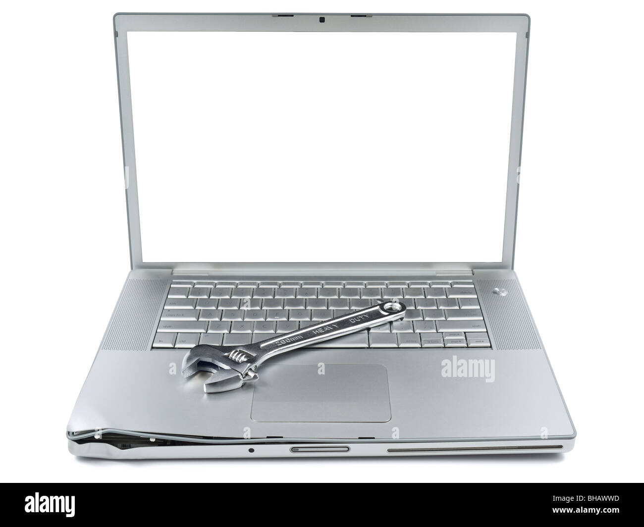 A spanner over a damaged laptop isolated over white background. White ...