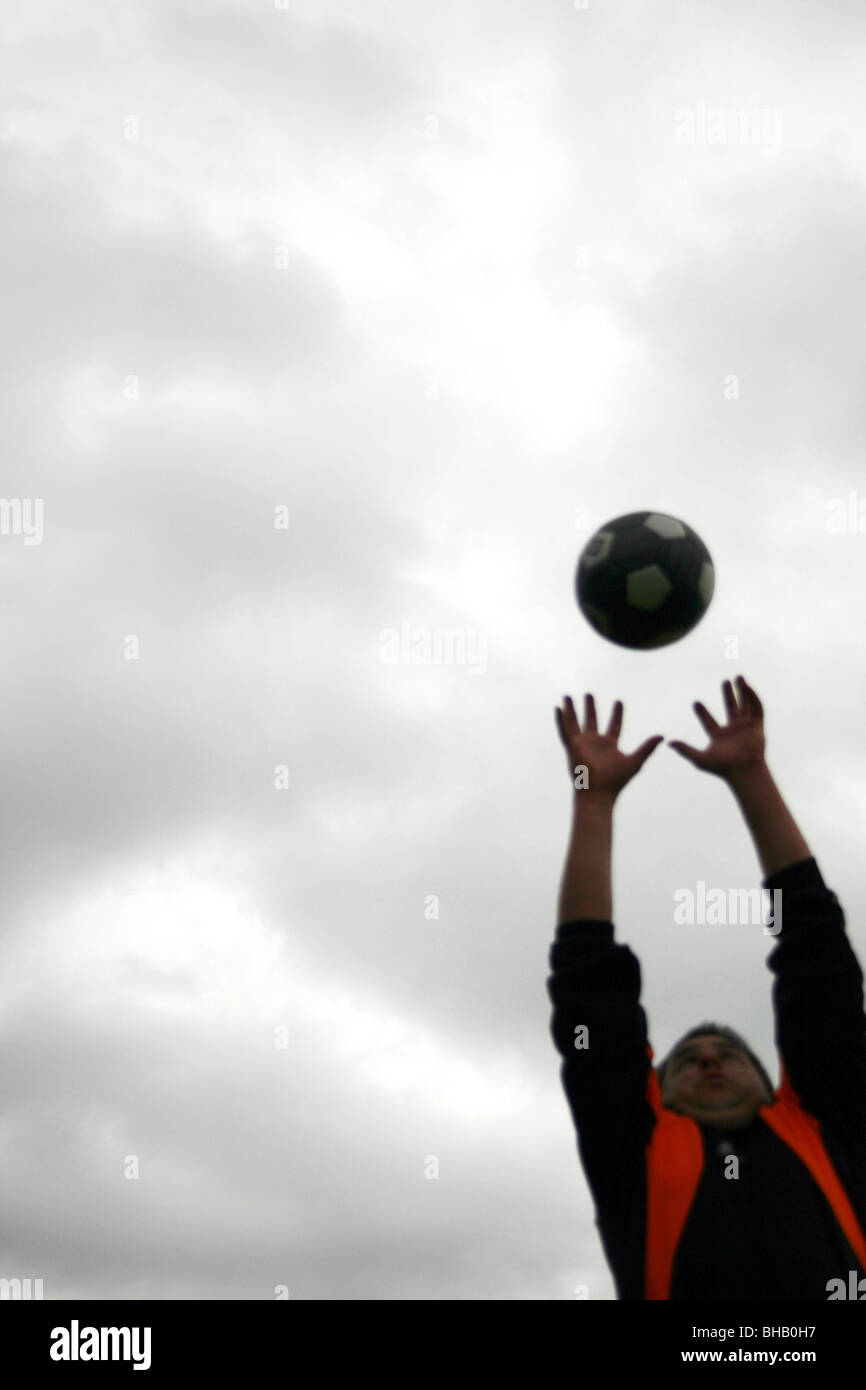 Goalkeeper leaps high to take a long crossed ball Stock Photo - Alamy