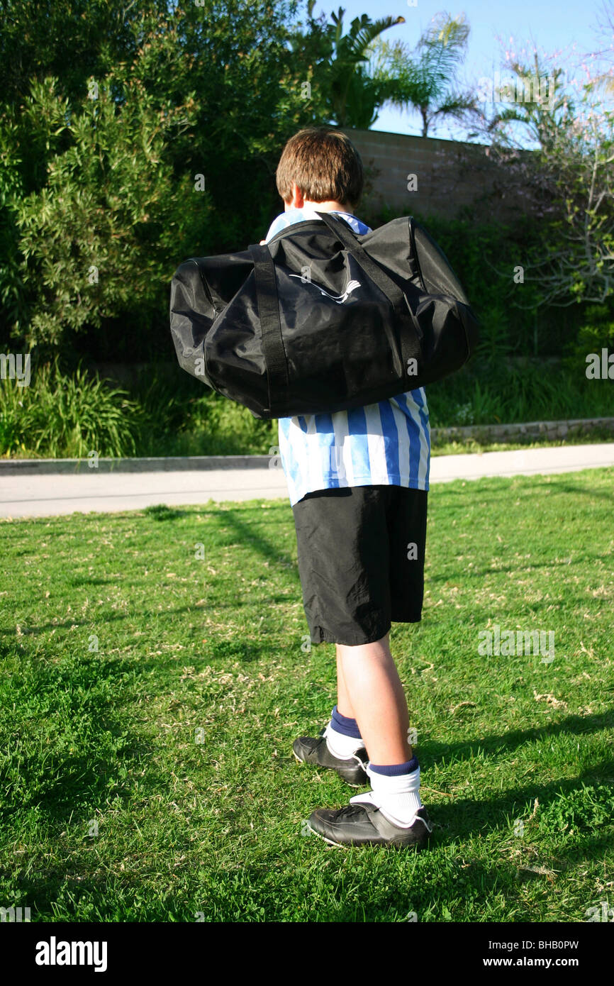 Footballer carrying his kit bag leaves field Stock Photo - Alamy
