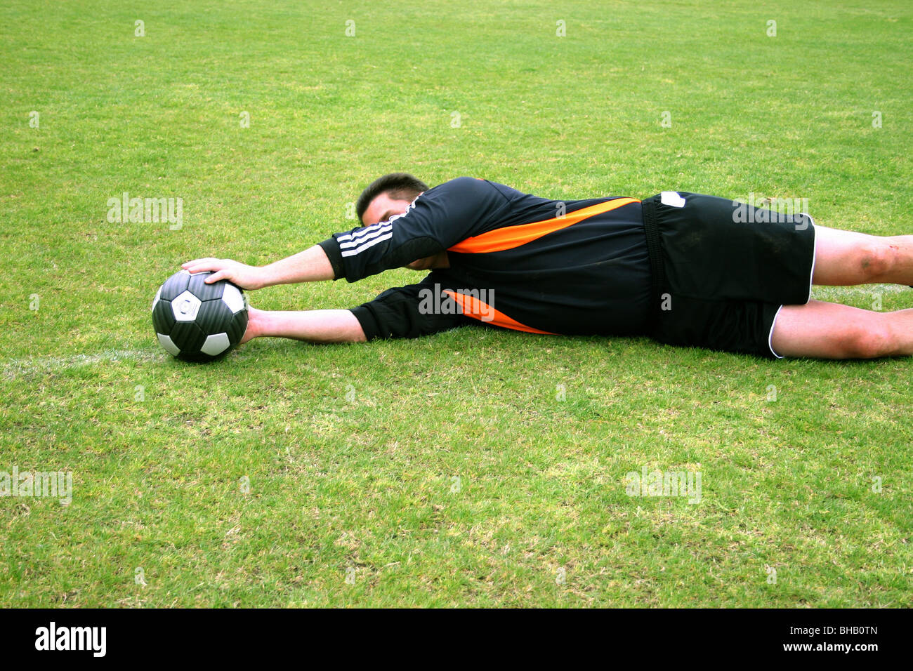 Goalkeeper makes diving stop to ensure football does not cross line and ...